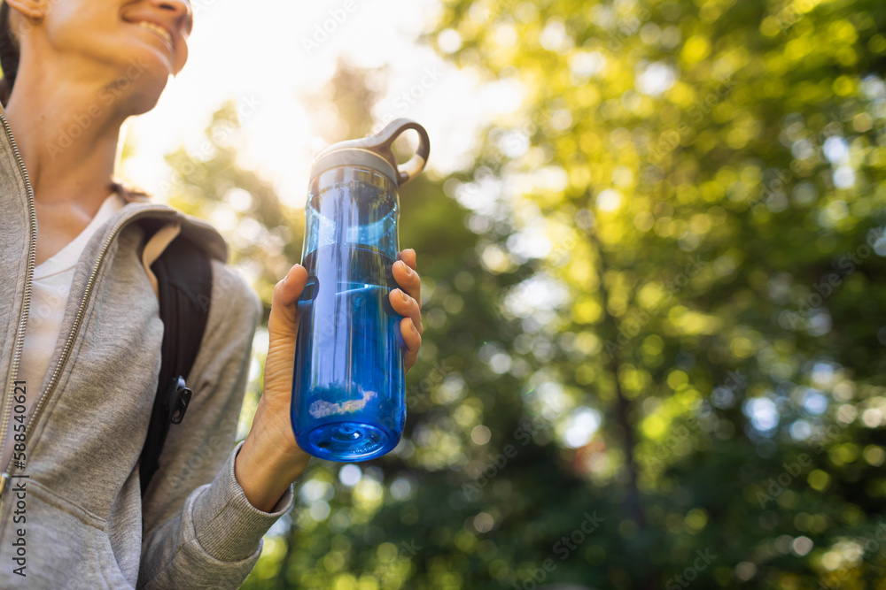 Active person holding bottle of water. Staying hydrated, drinking water ...