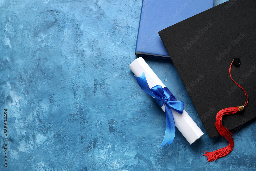 Diploma with ribbon, graduation hat and book on blue table Stock Photo ...