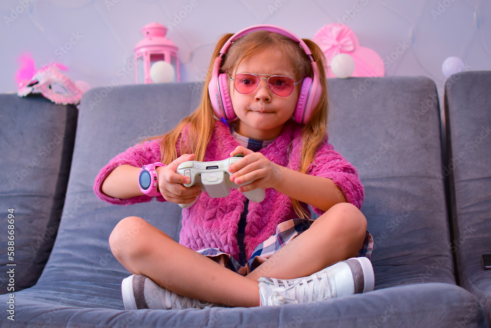 Child gamer. The unique child plays video games expressively. A ...