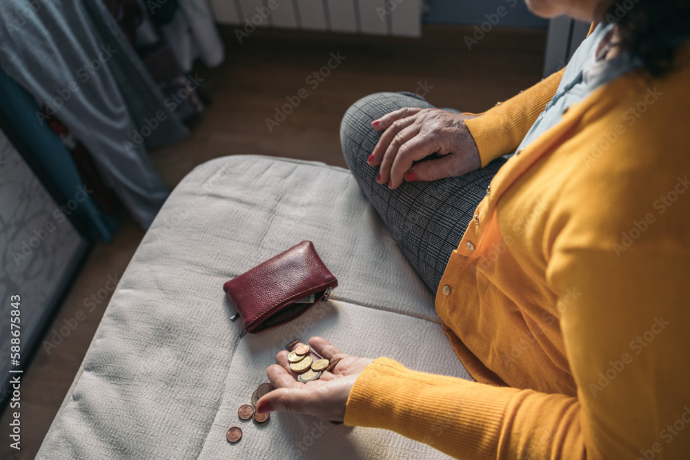 Rear aerial image of an older woman sitting up in bed taking coin money ...