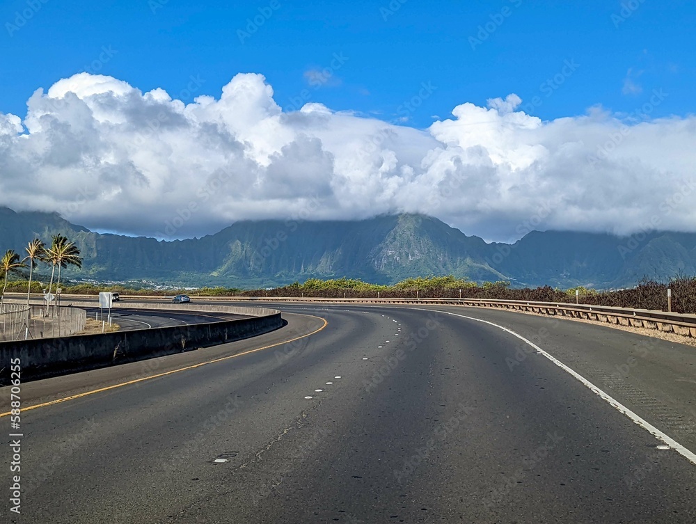 Scene of the road between mountains and palm trees with heavy white ...