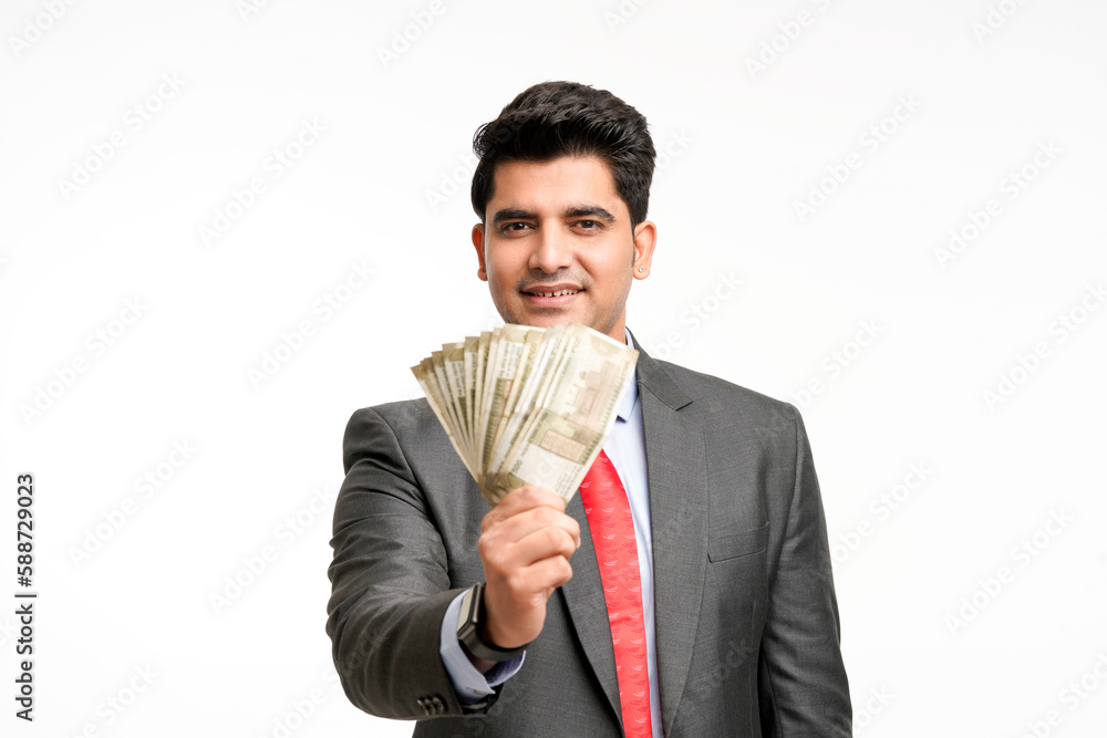 Young indian man in suit and showing indian rupees on white background ...
