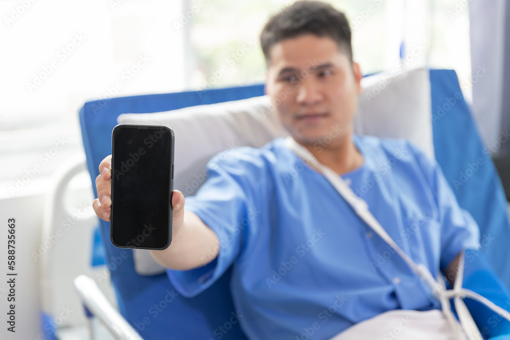Male patient at hospital holding a smart phone with a blank screen ...