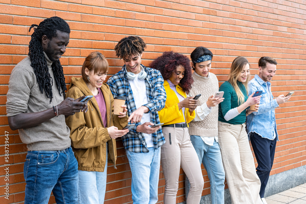 Young people looking down at cellular phone, teenagers leaning on a ...