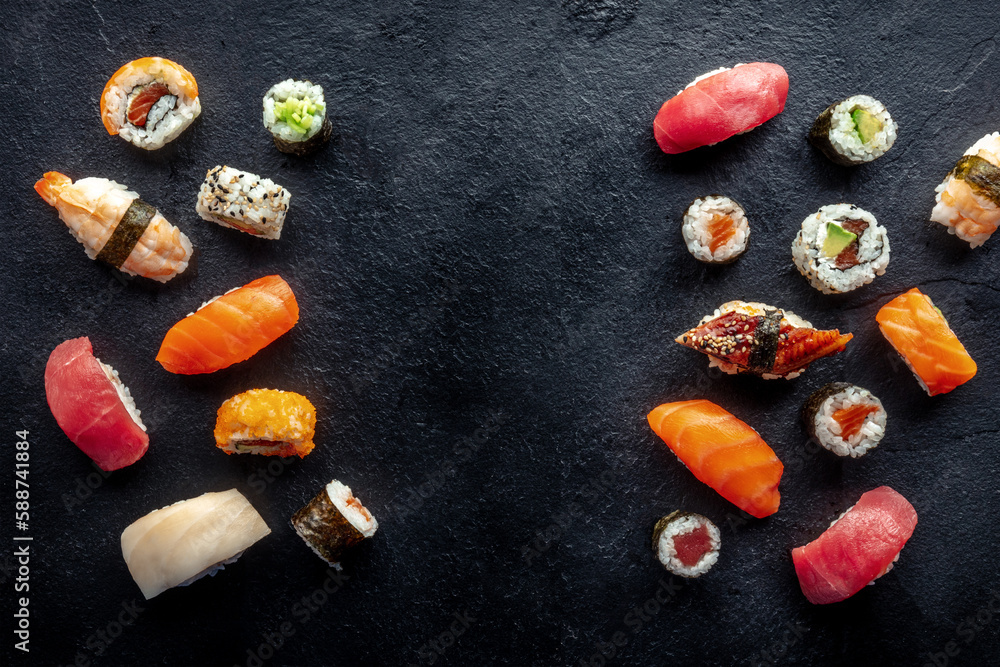 Sushi frame, a flat lay, top shot. Rolls, maki, nigiri on a black slate ...
