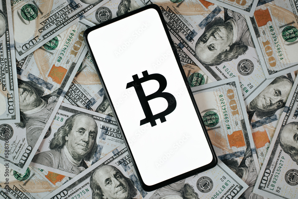 Bitcoin cryptocurrency symbol on screen of smartphone lying on money ...