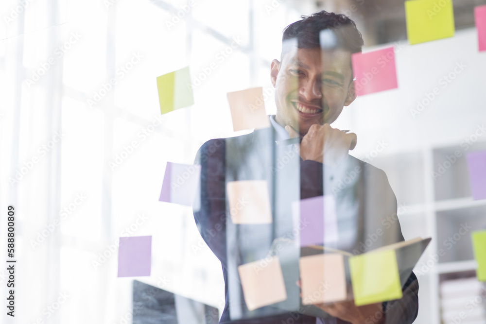 Concentrated adult business asian man, organizing his busy work week in ...
