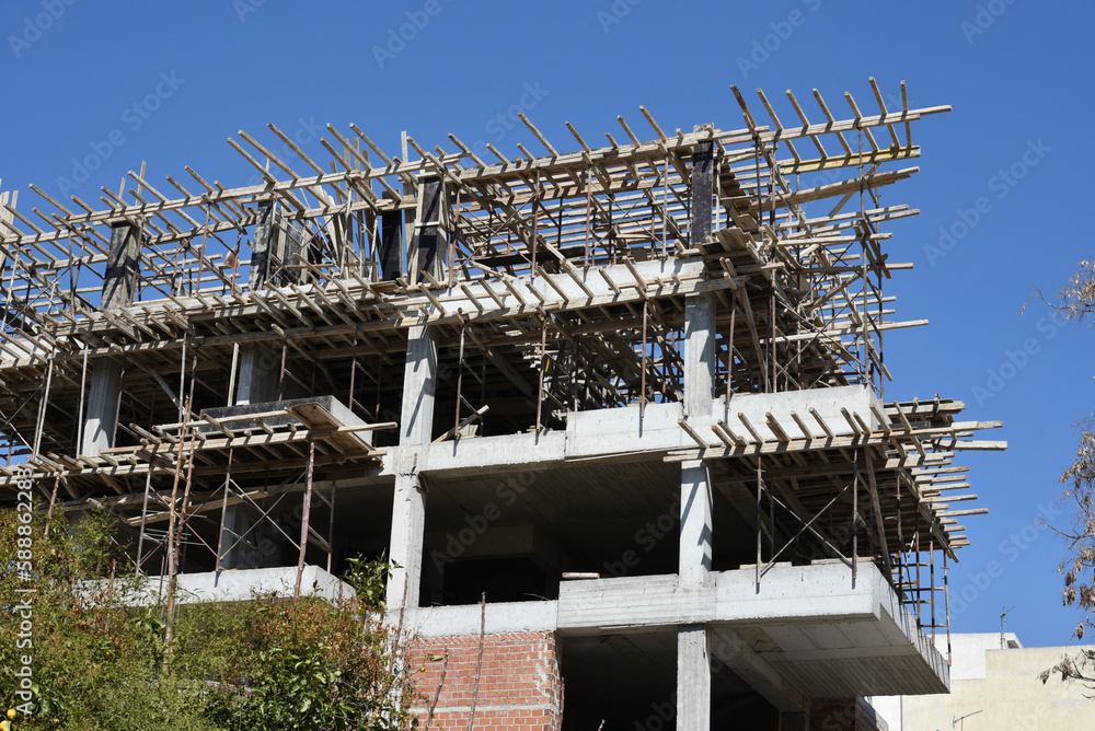 Building under construction at early stages, with blue sky background ...