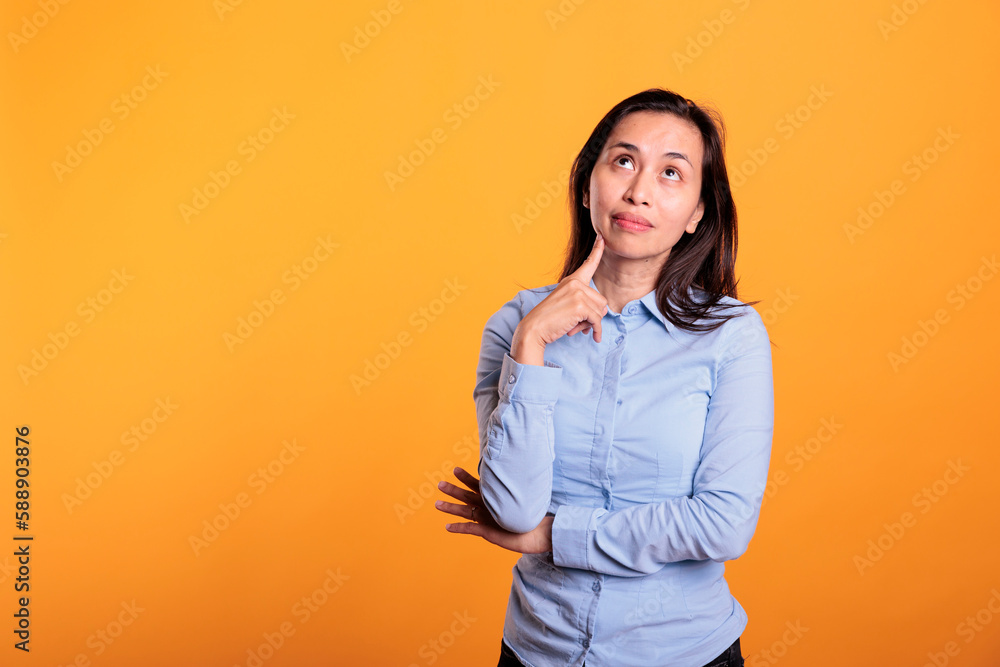 Filipino woman thinking with finger on chin in front of camera in ...