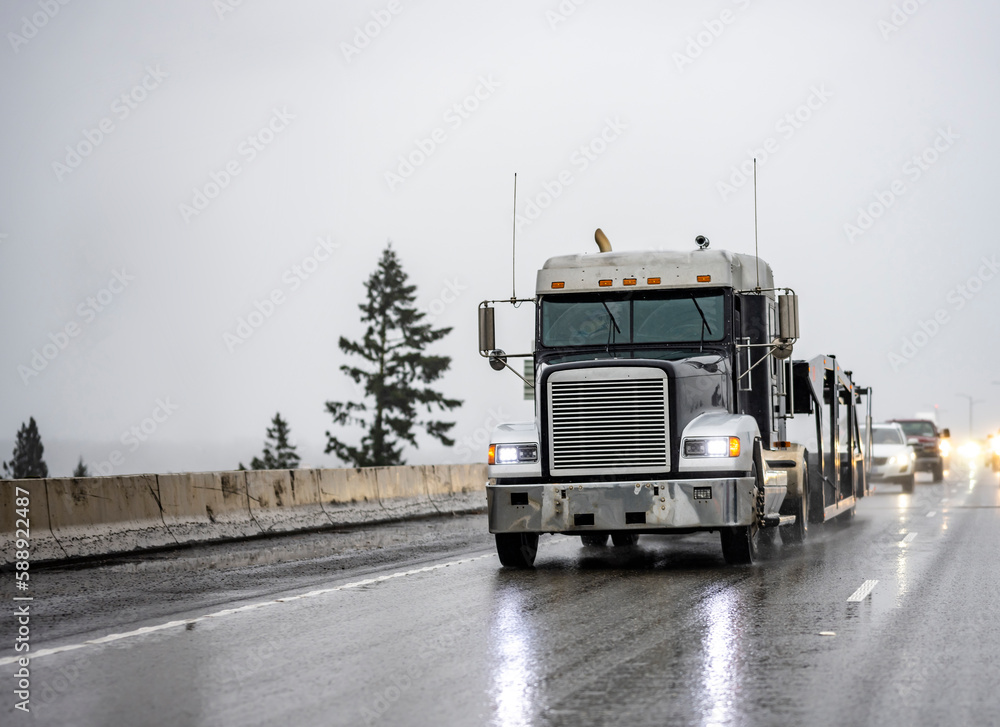 Black classic big rig semi truck with car hauler empty semi trailer ...
