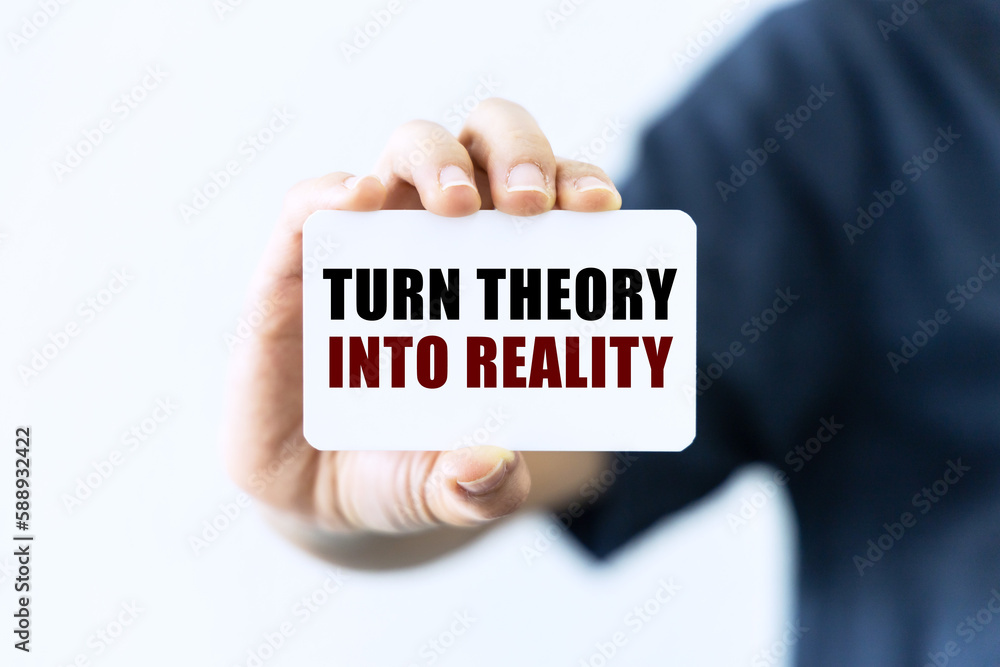 Turn theory into reality text on blank business card being held by a ...