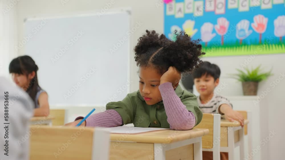 African American student doing exam in classroom at elementary school ...