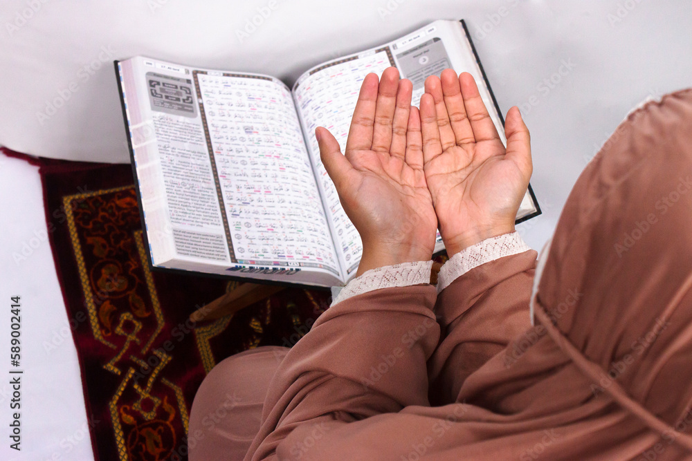 Islamic moslem woman praying Koran or Quran on praying carpet sajadah ...