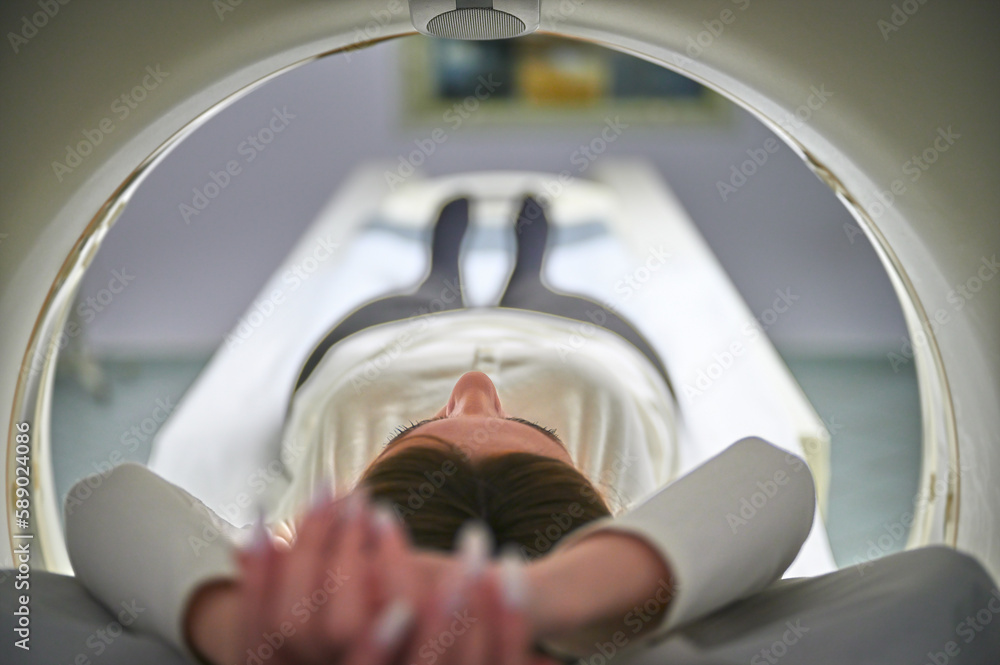 A young pretty girl is undergoing a CT scan in a medical clinic ...