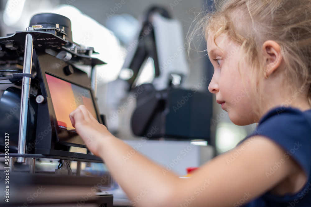 girl female teen children concentrate look Machine Learning Robot is Moving Under Control robot ...