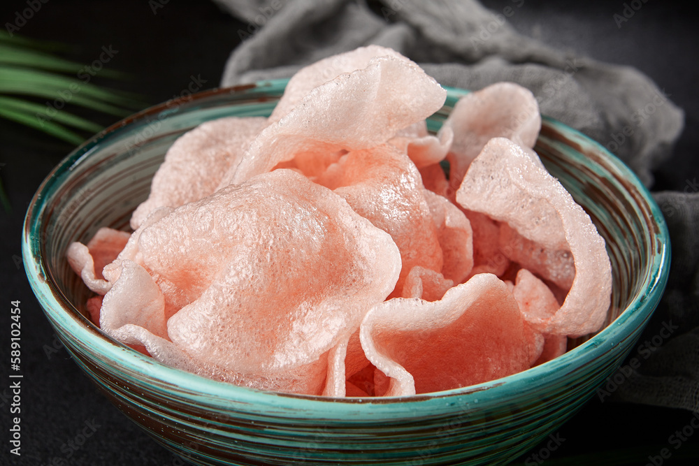 Traditional chinese shrimp crackers in ceramic bowl on black background ...