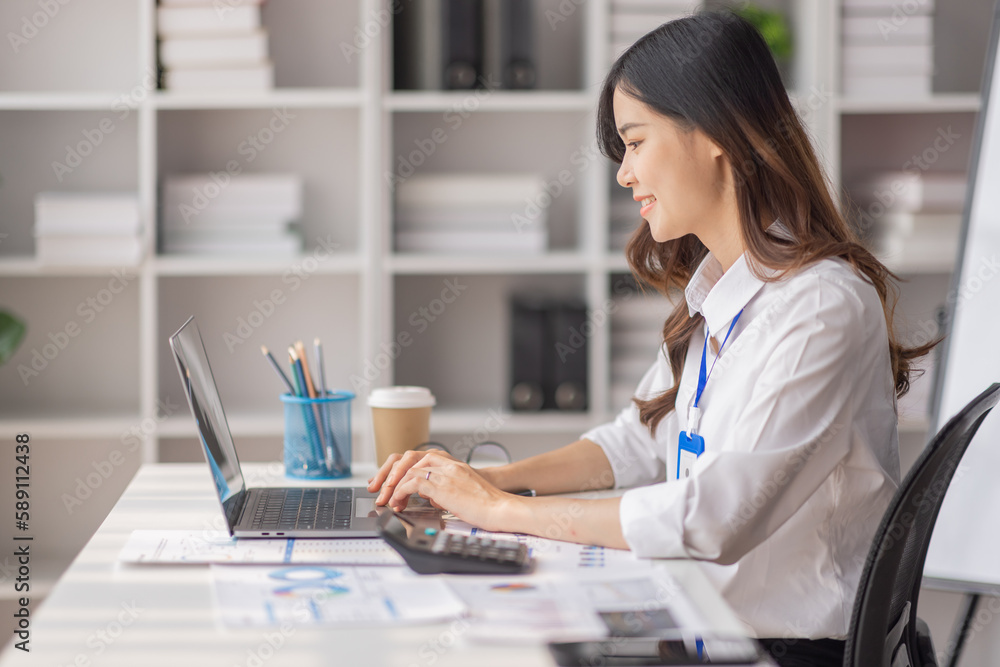 Charming Young asian businesswoman sitting on laptop computer in the ...