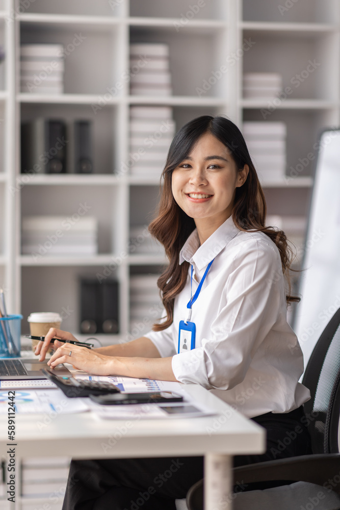 Charming Young asian businesswoman sitting on laptop computer in the ...