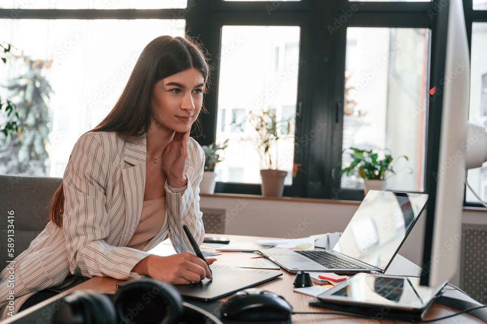 Drawing by using graphic tablet. Woman is working in the modern office ...