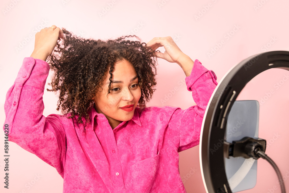 Calm ethnic woman demonstrating hairstyle during beauty tutorial Stock ...