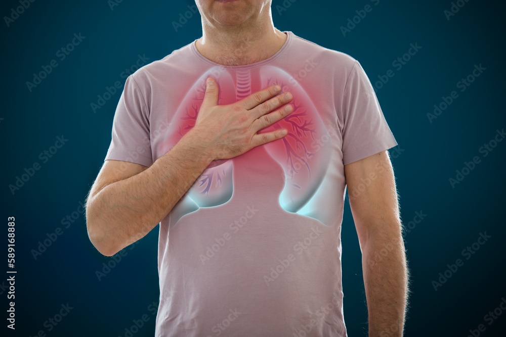 The man standing on a dark background. Picture of a human lungs with ...