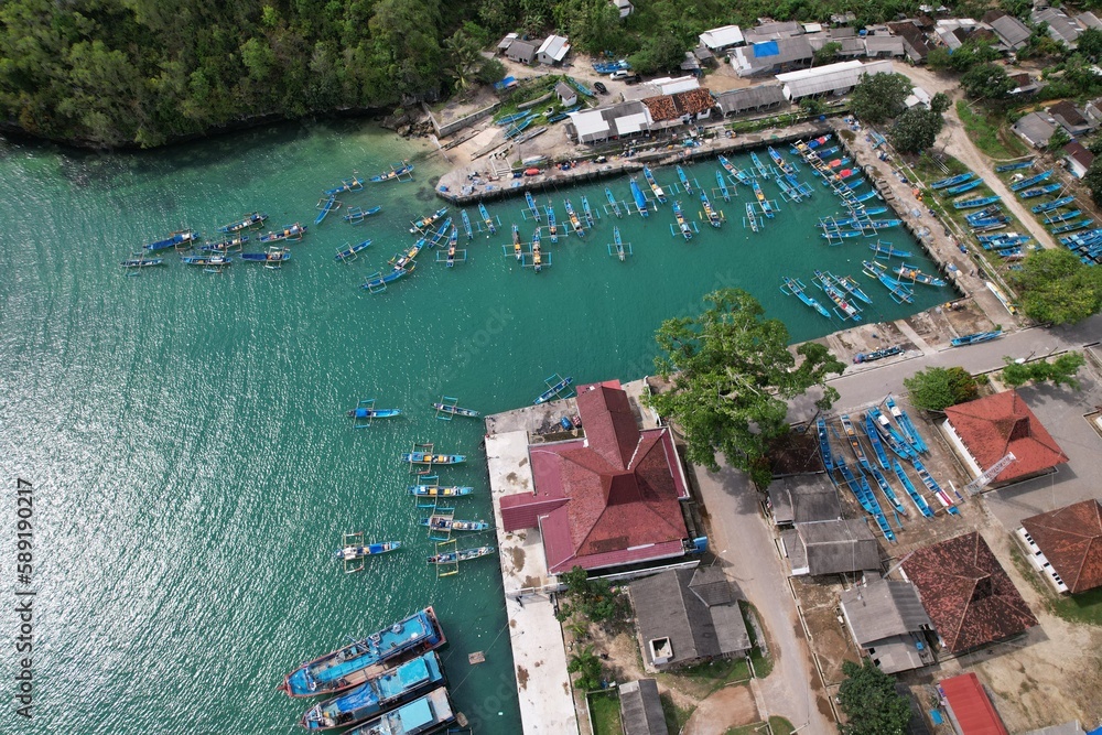 blue and white fishing boat anchored in a harbor. aerial photography of ...