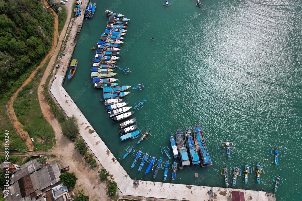 blue and white fishing boat anchored in a harbor. aerial photography of ...