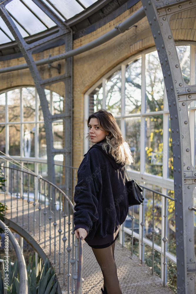 Young woman in botanical garden. She explore different types of trees ...
