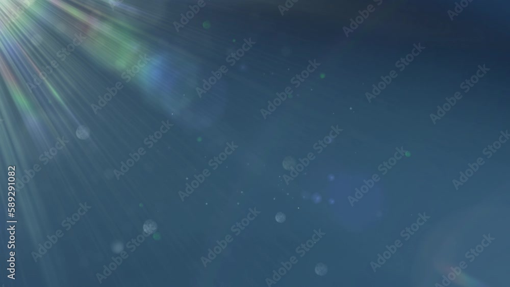 Spectrum lens flare and floating particles over blue color gradient ...