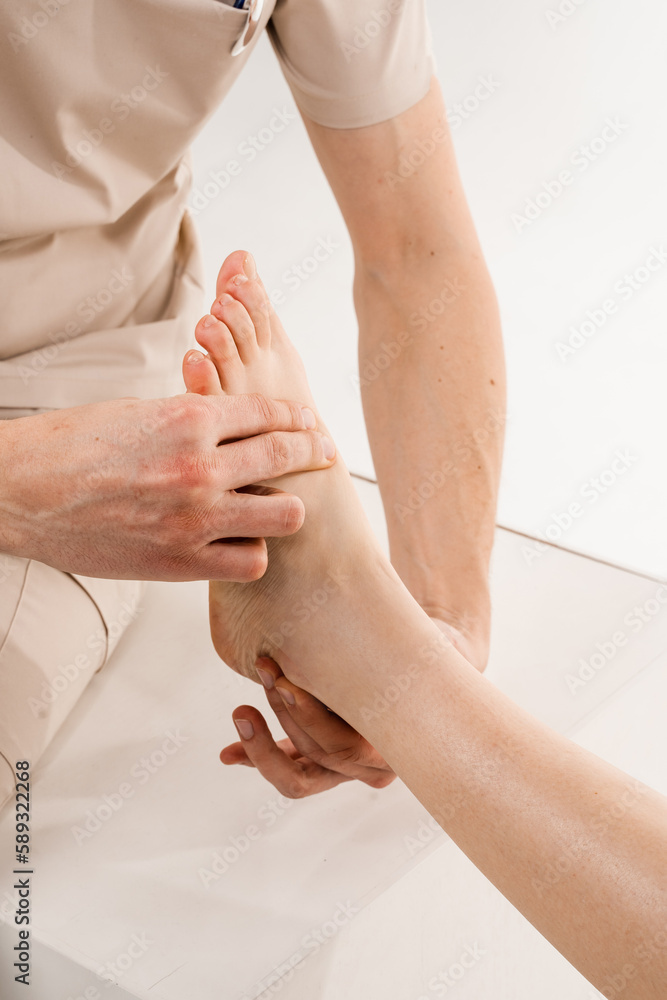 Orthopedist is touching and pressing foot for assessment of the volume ...