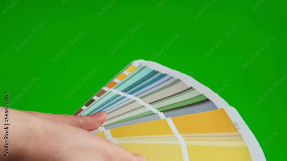 Hands choose the color using the sample swatch on blank green screen ...