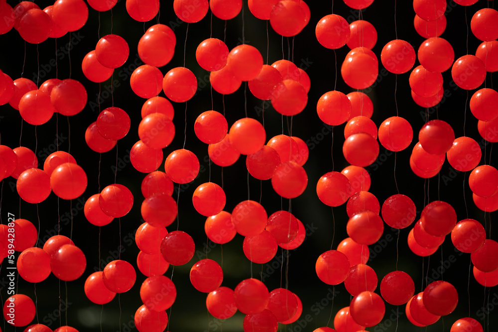 Red balls suspended on wire, outdoor art object symbolizing blood cells ...