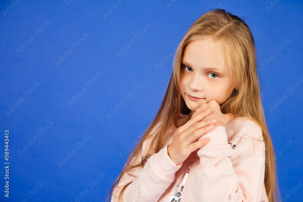 Sad little girl in white sweater thinking at blue background, thought ...