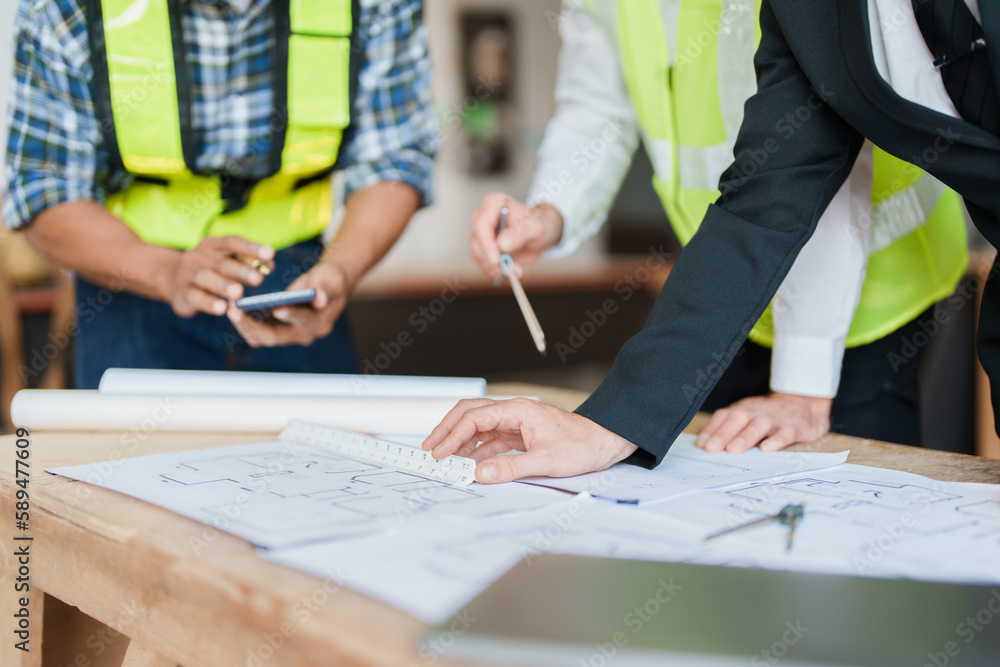 multi ethnic engineer brainstorming and measuring for cost estimating ...