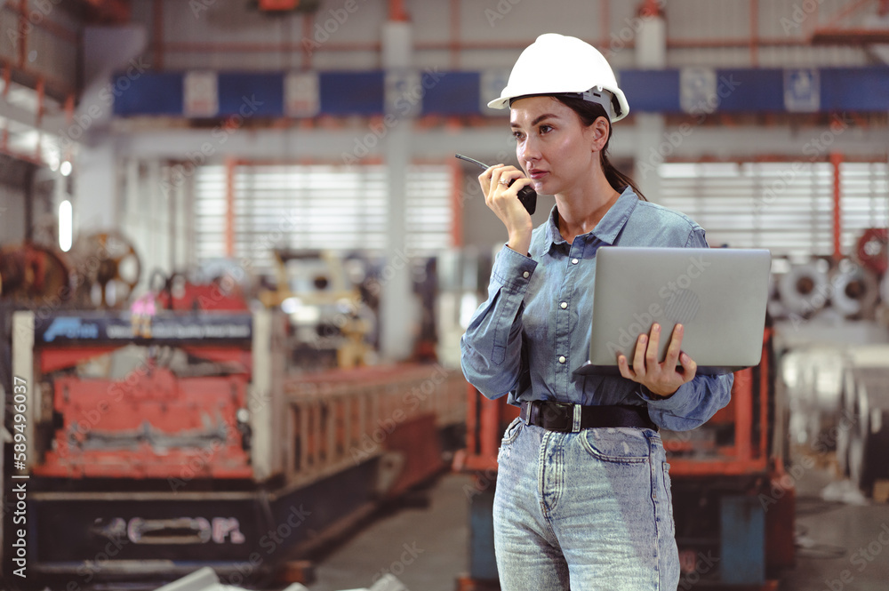 Young factory manager wears white safety helmet standing at machinery ...