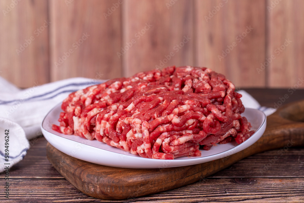 Beef minced on the plate. Fresh ground beef on wood background. Stock ...