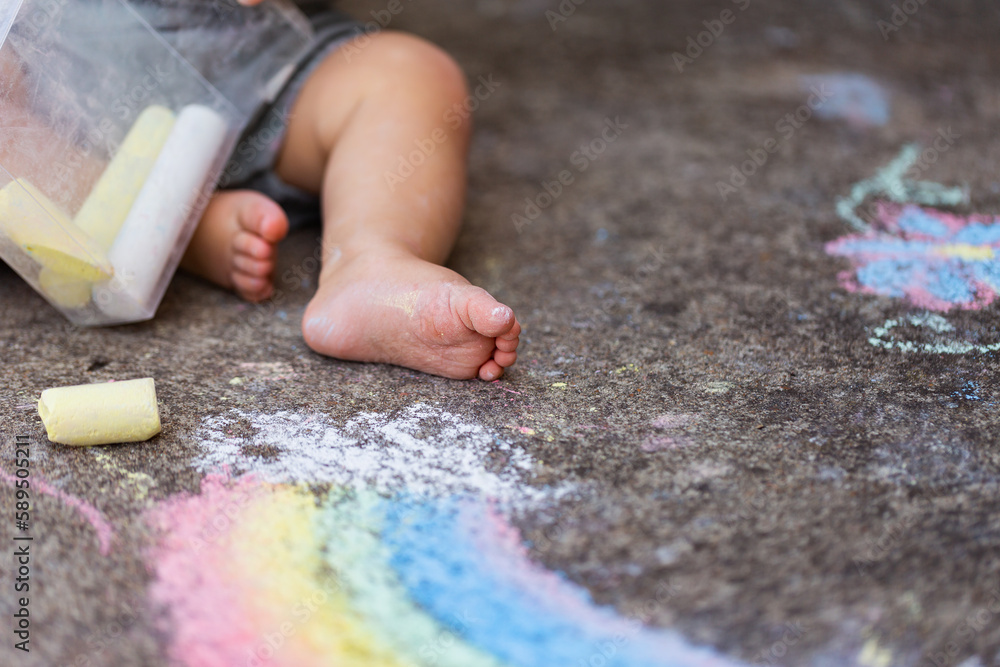 chalk covered foot of baby on concrete with rainbow art drawing foto de ...