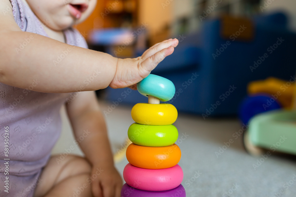 Baby learning through play developing fine motor skills with colourful ...