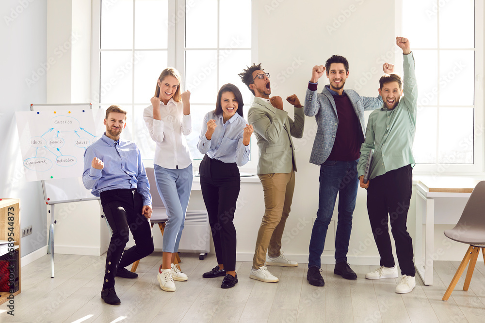 Happy business team celebrating success. Group of joyful, excited young diverse people having ...