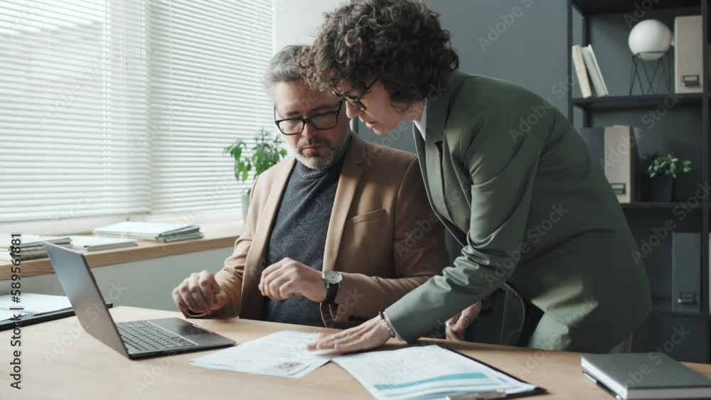 Stockvideo Medium shot of grey-haired spectacled businessman working on ...
