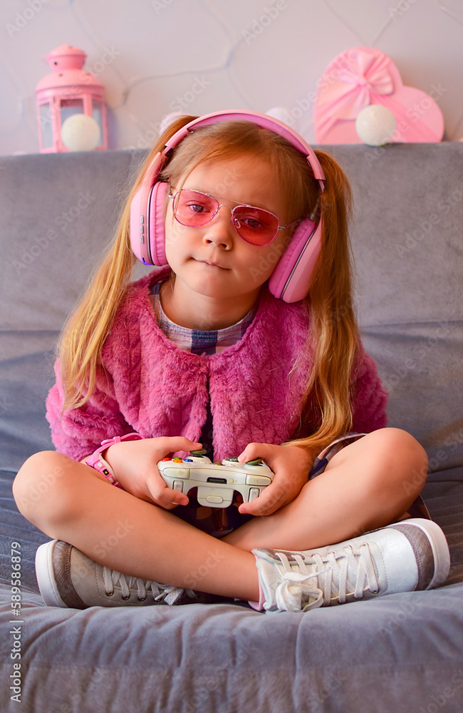 Child gamer. The unique child plays video games expressively. A ...