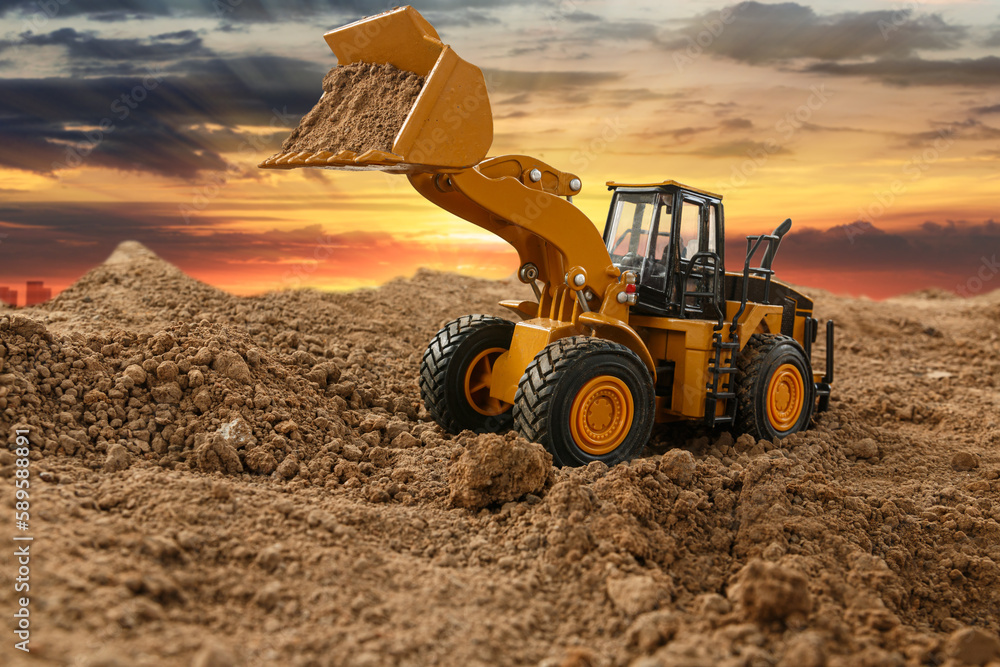 Wheel loader are digging the soil in the construction site on sunset ...