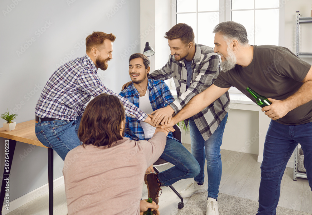 Group of male friends putting hands together in stack pile. Cheerful ...
