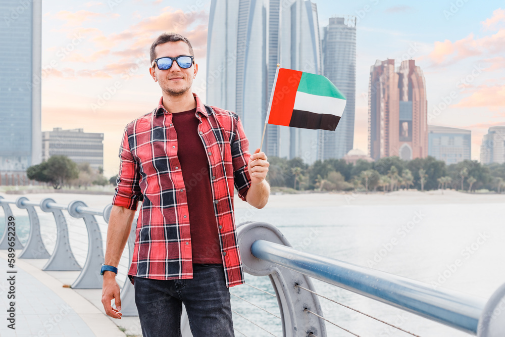 A proud UAE citizen poses with the national flag, embodying the ...