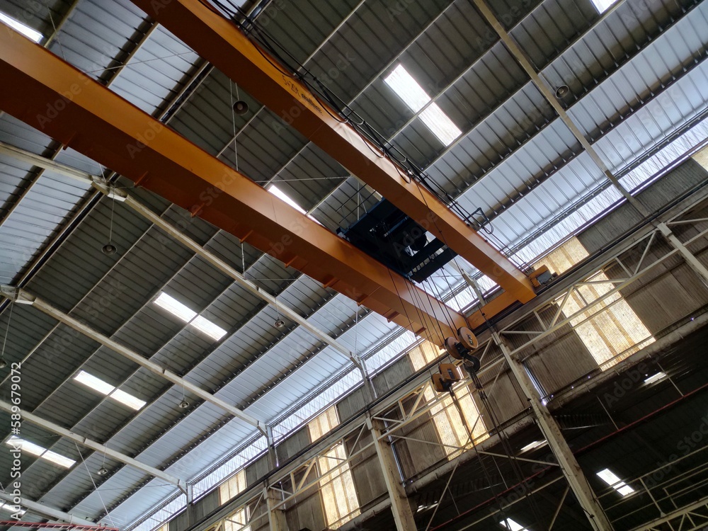 Yellow overhead crane installed on the manufacturing industry plant ...