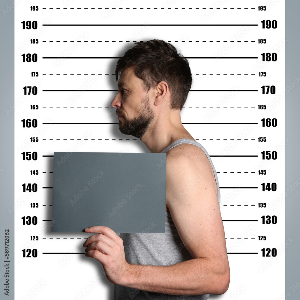 Criminal mugshot. Arrested man with blank card against height chart ...