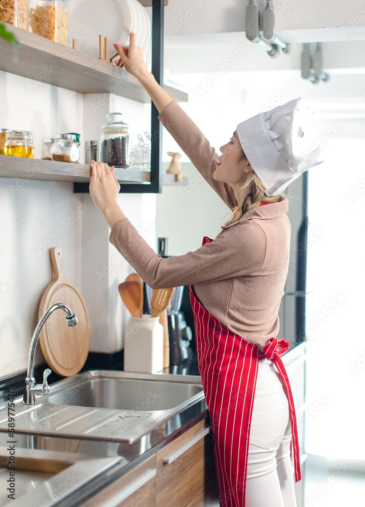 Millennial Asian young cheerful female housewife chef wearing white ...