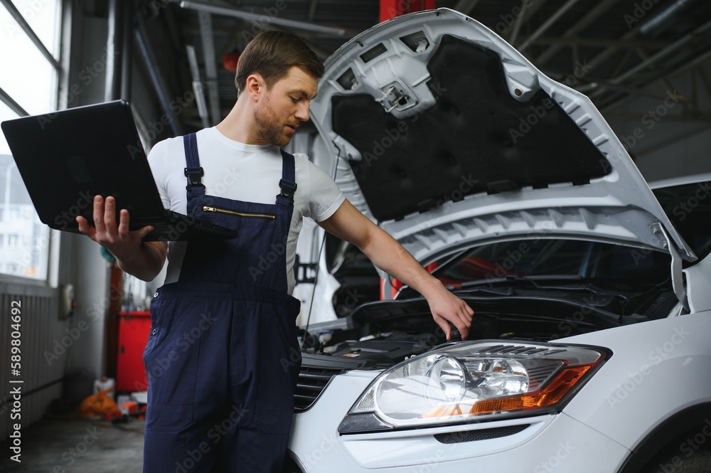 Mechanic man mechanic manager worker using a laptop computer checking ...