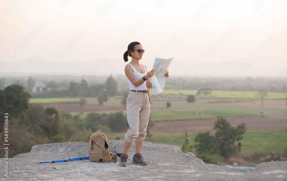 Adventurous girl navigating in with a topographic map in the beautiful ...
