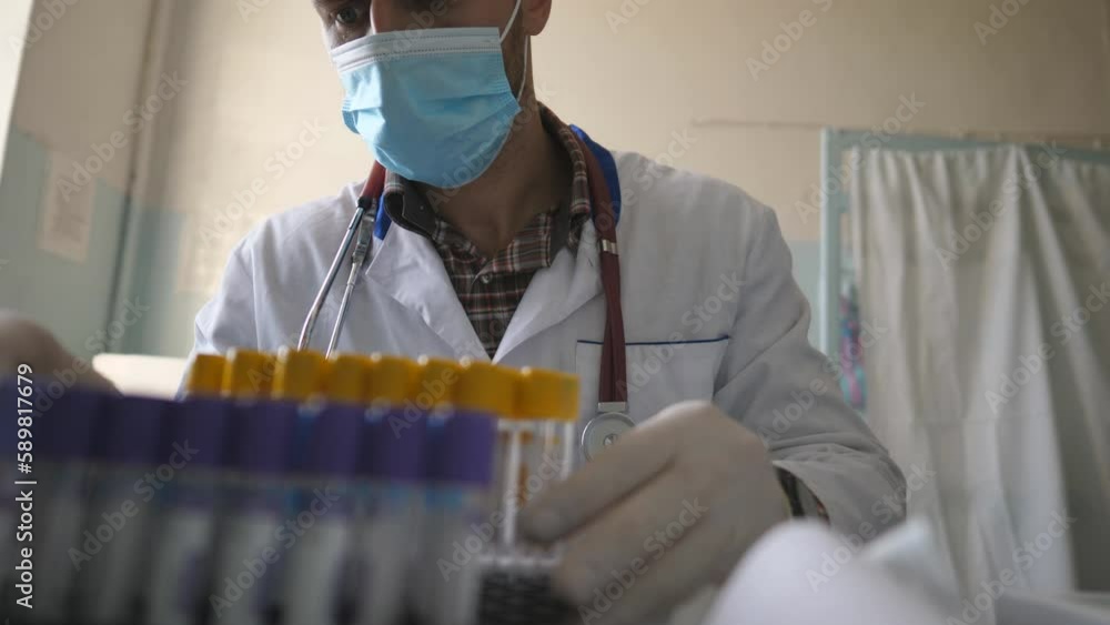 Doctor wearing medical uniform checking and viewing test tubes ...